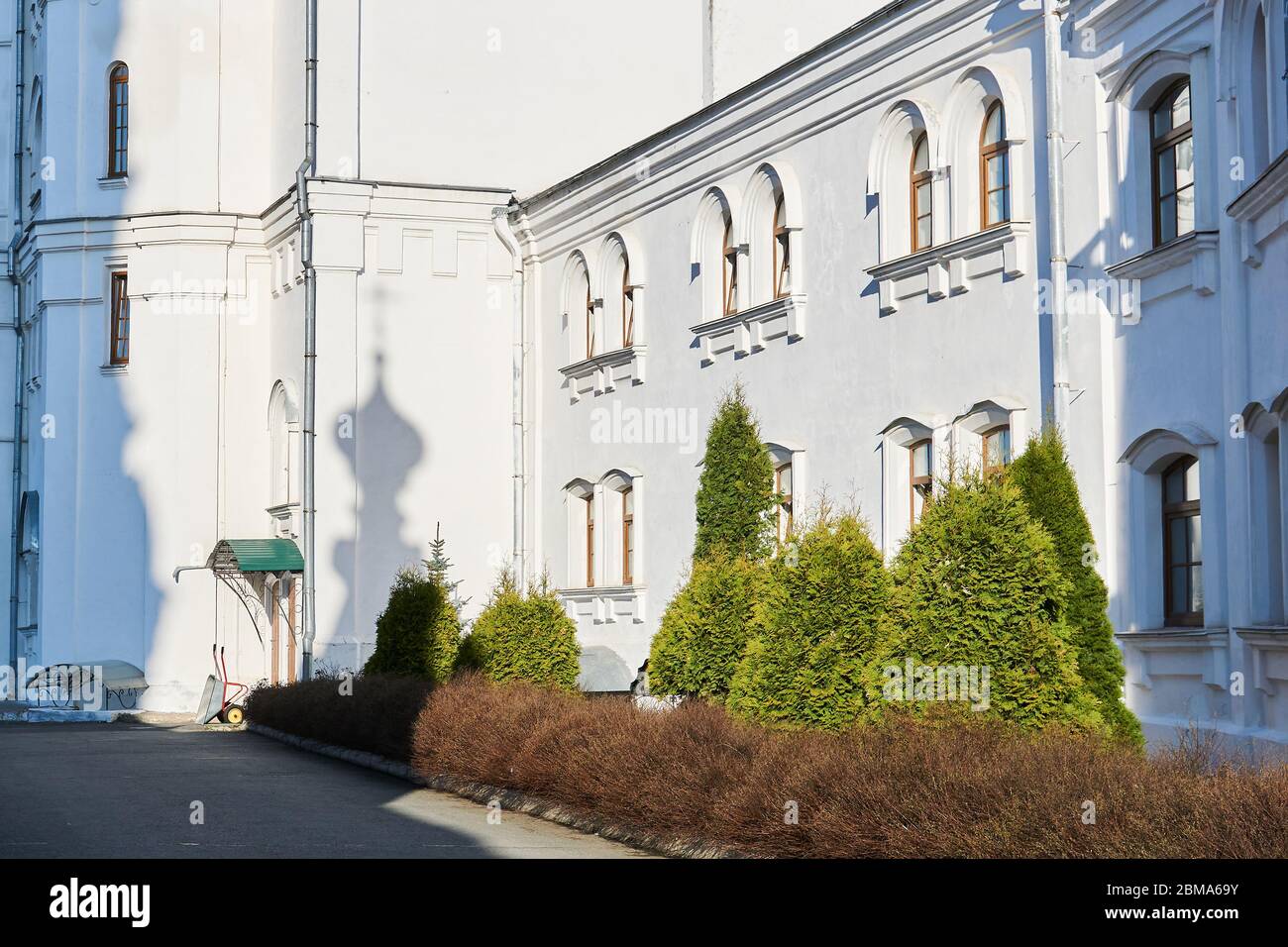 courtyard of an old orthodox monastery with junipers and a shadow from ...