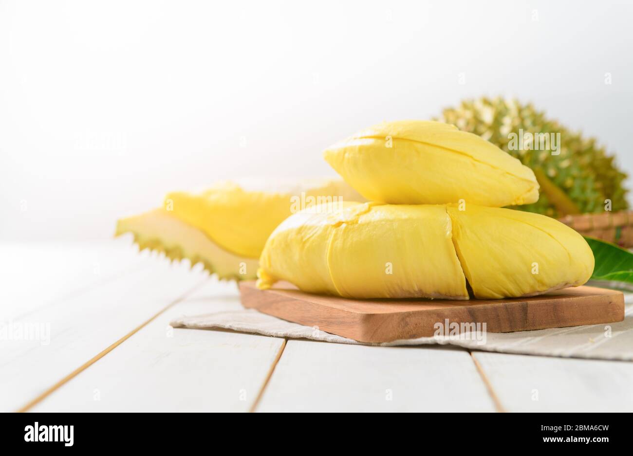 Fresh cut durian (monthong) on wood block and white wood background, king of fruit from Thailand ...