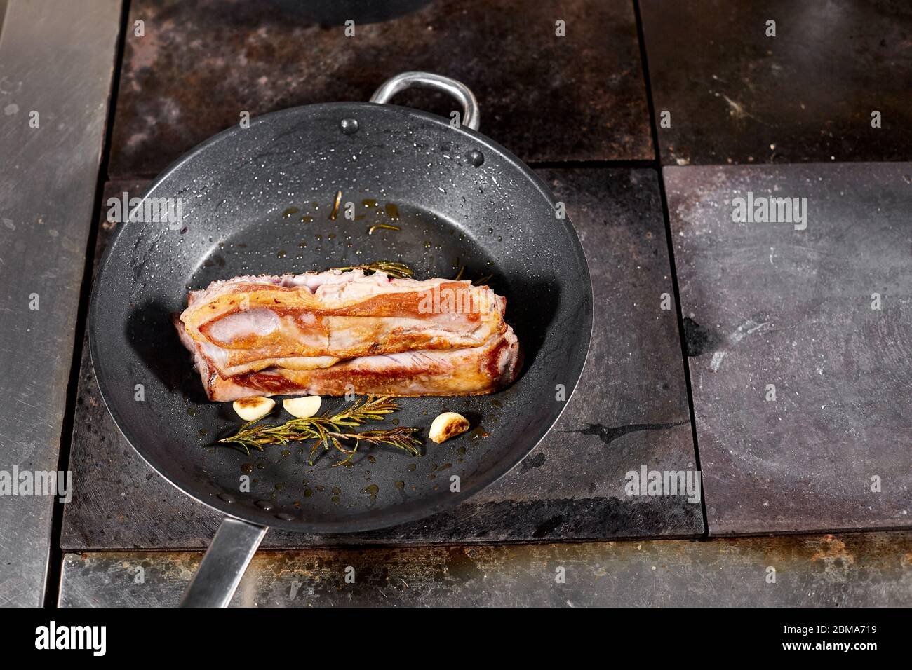 fried ribs of lamb. Cooking with fire in frying pan. Professional chef ...