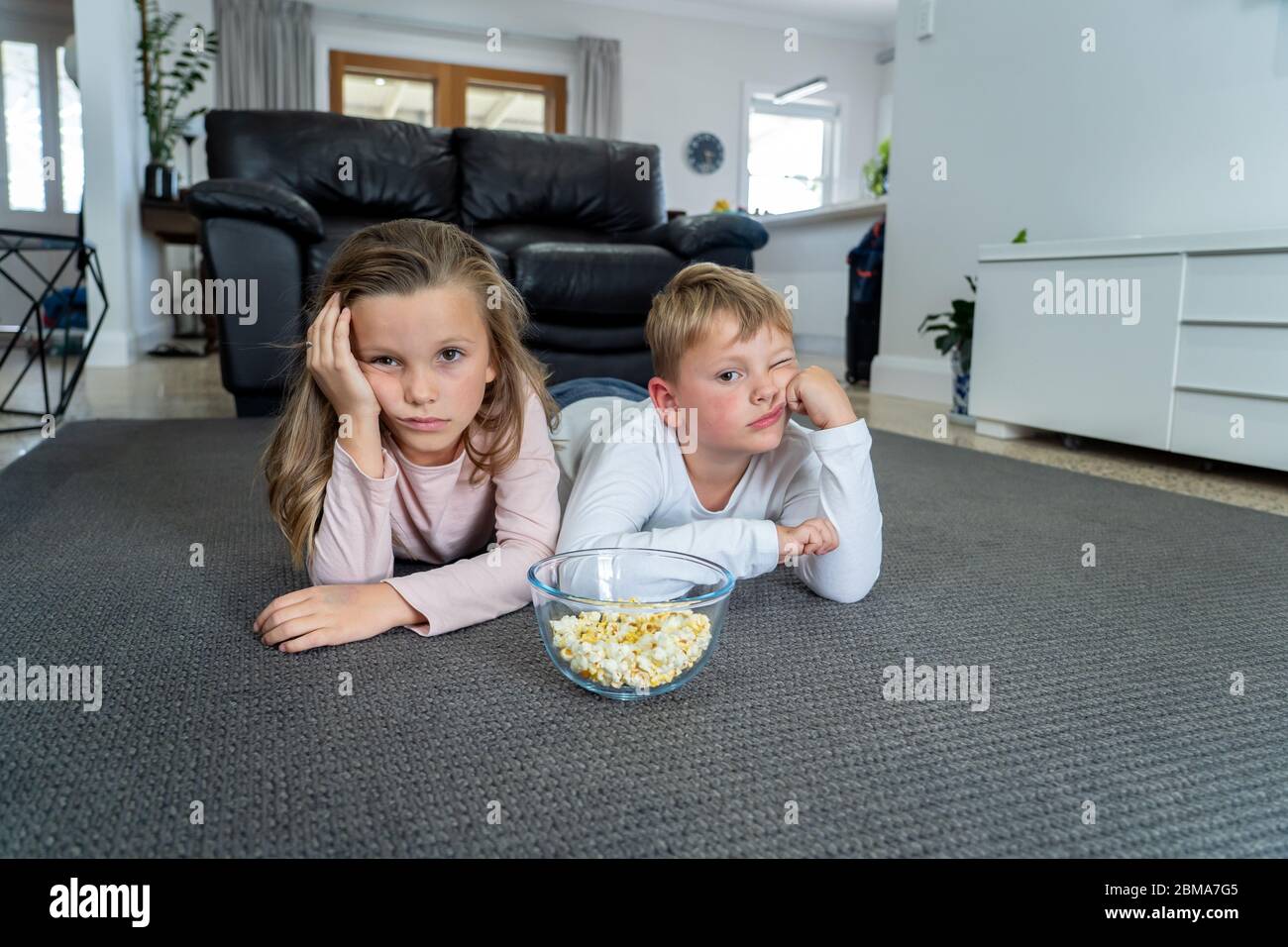 Coronavirus lockdow. Bored little girl and sad boy watching tv in ...