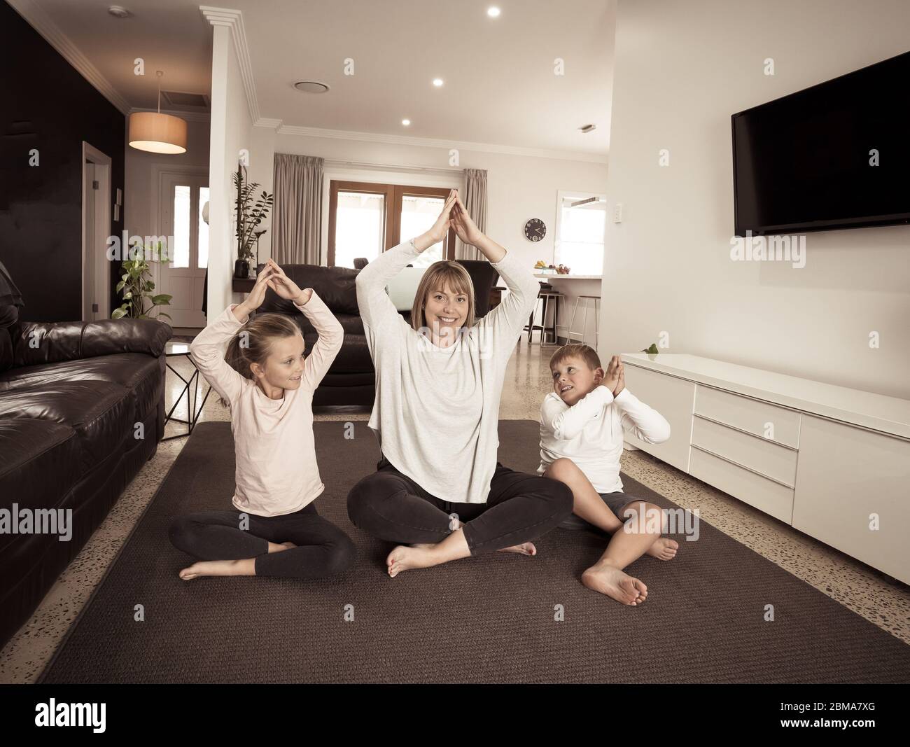 COVID-19 Shutdown. Caucasian family doing yoga at home in quarantine ...