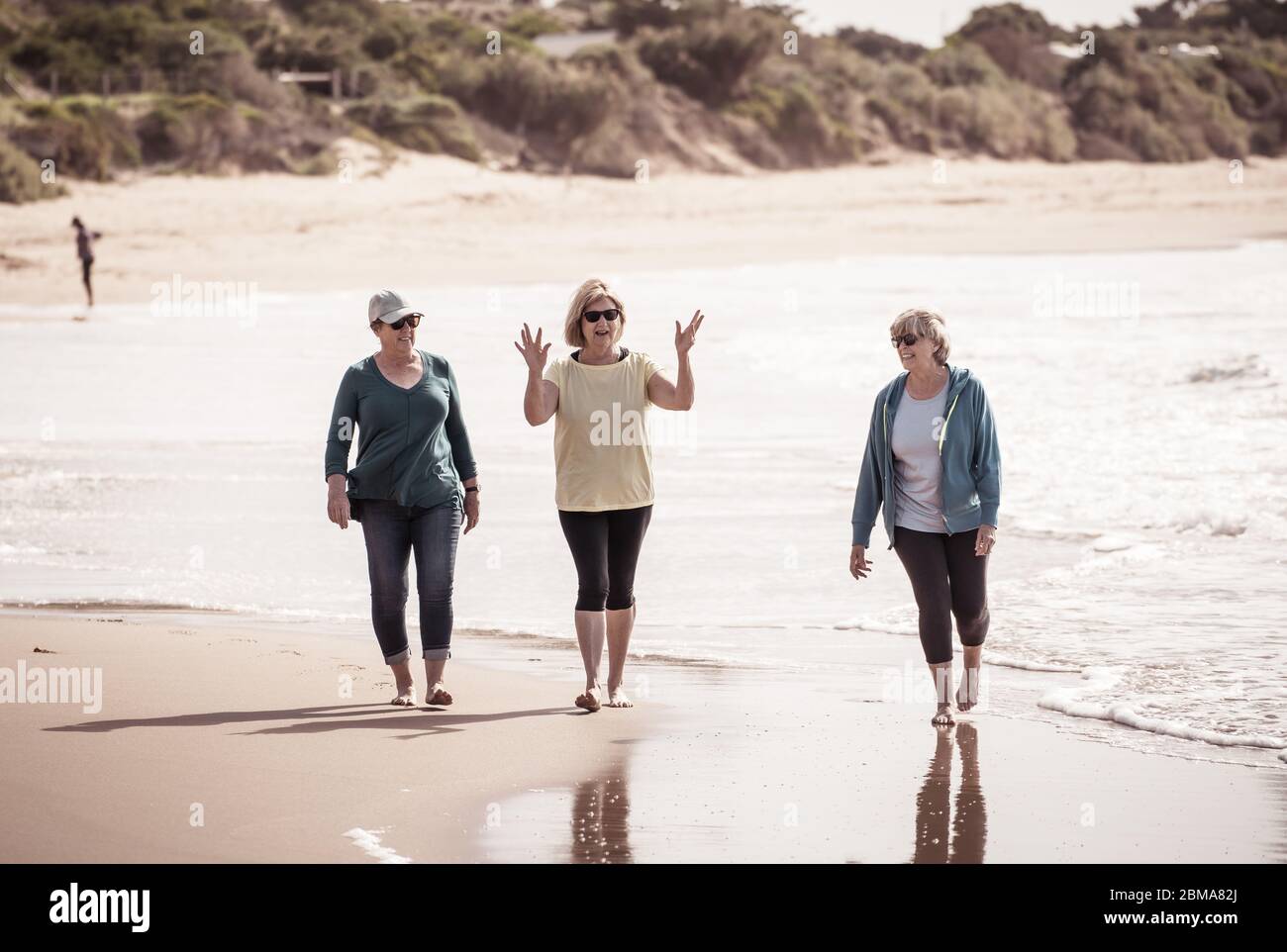 Group of three senior retired woman from elderly home walking together ...