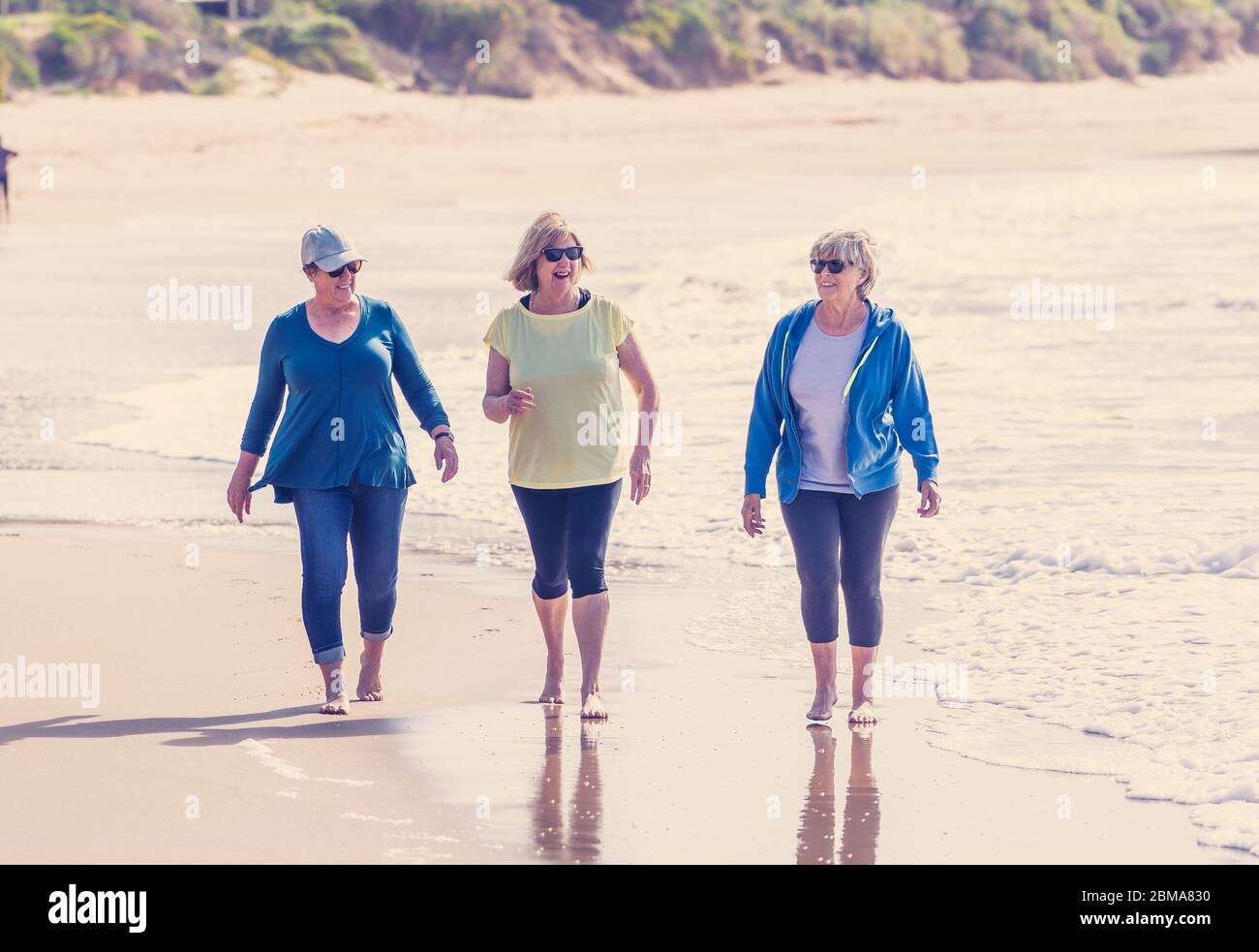 Group of three senior retired woman from elderly home walking together ...