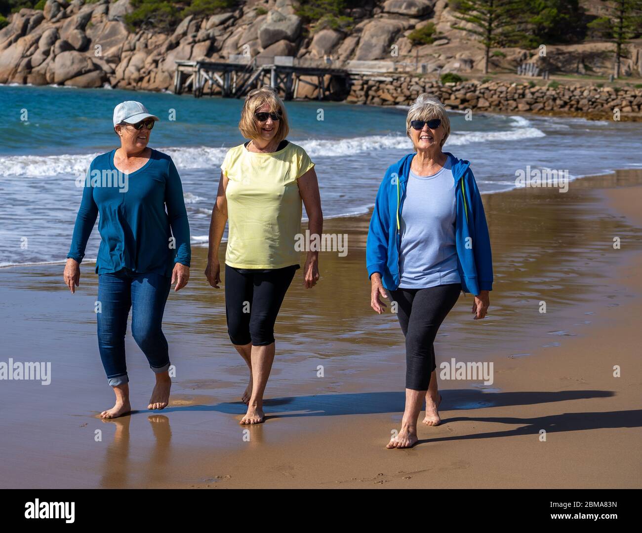 Group of three senior retired woman from elderly home walking together ...