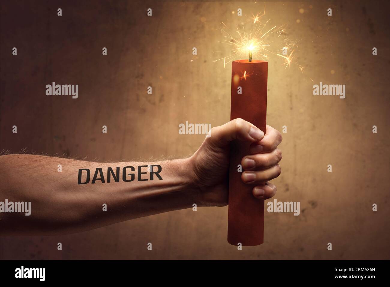 Danger concept - Hand holding a burning stick of dynamite Stock Photo ...