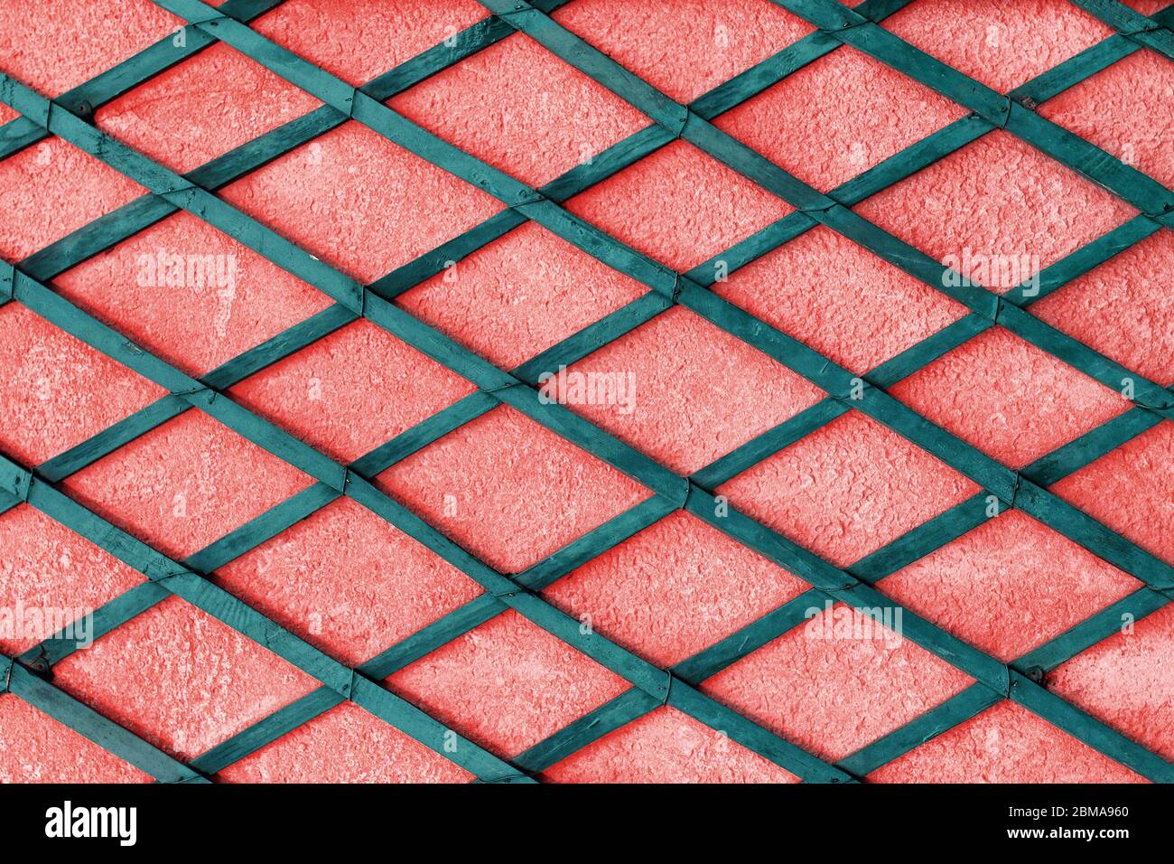 Abstract coral color wall with green wooden planks as a rhombus pattern ...