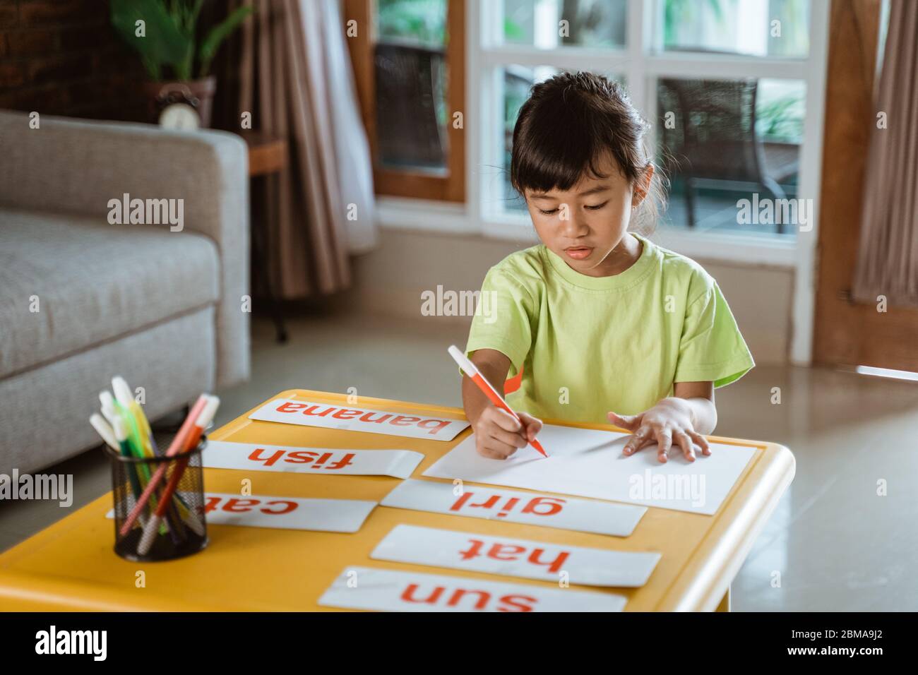 little girl learning to read by herself at home. kid studying alone ...