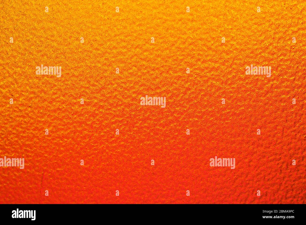 Horizontal image. The background is orange, shading to a deep yellow ...