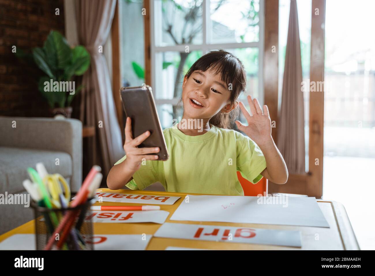 little girl studying from home during self isolation. learning using ...