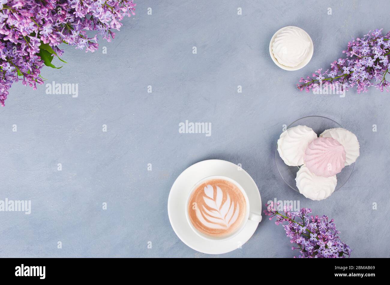 Lilac, coffee with latte art and marshmallows on gray wooden table ...