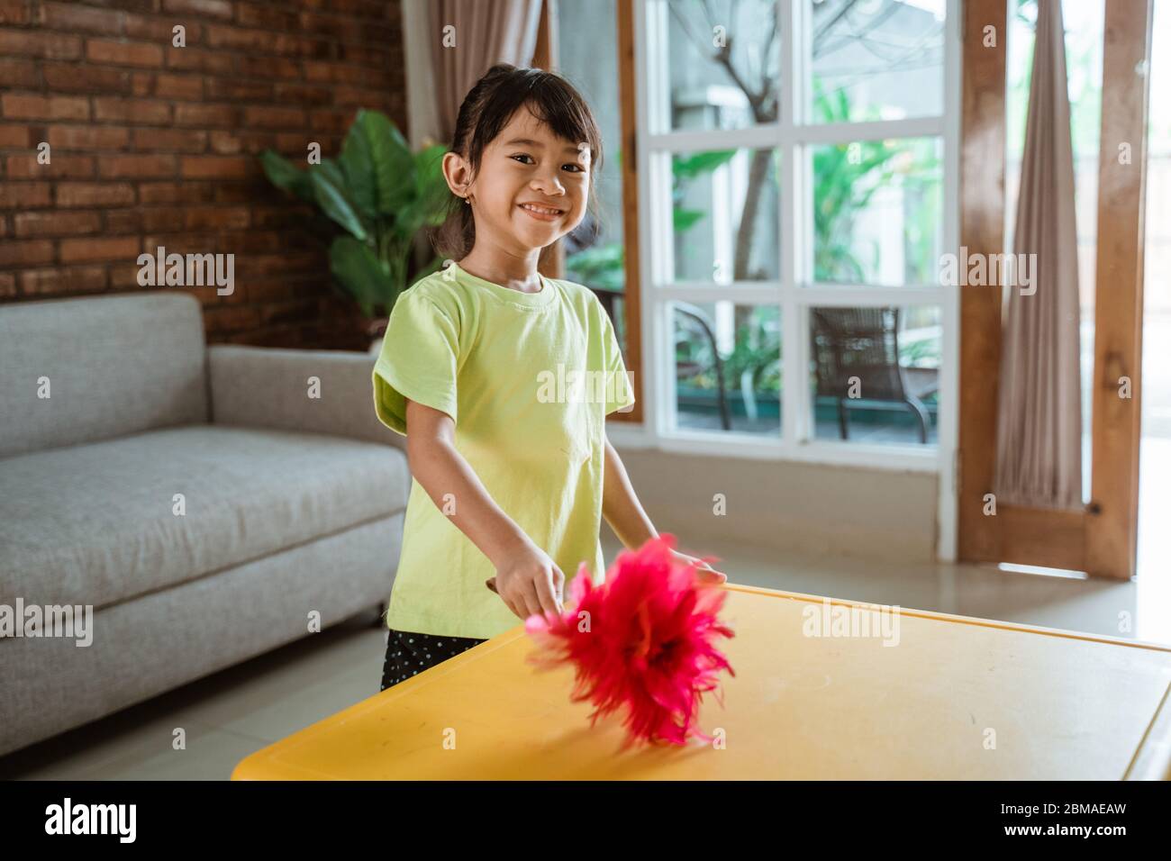 little kid cleaning up the table by herself Stock Photo - Alamy