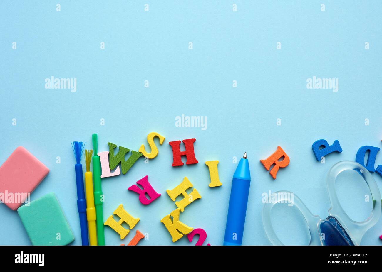 multi-colored wooden letters of the English alphabet, paint brushes ...