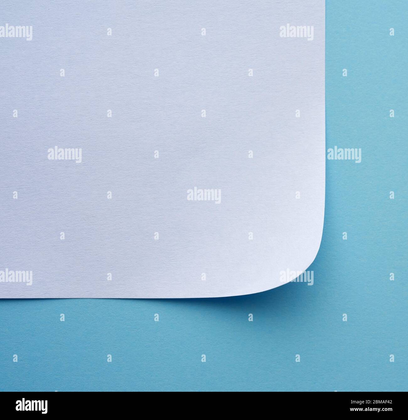 wrapped sheet of white paper on a blue background, macro, top view ...