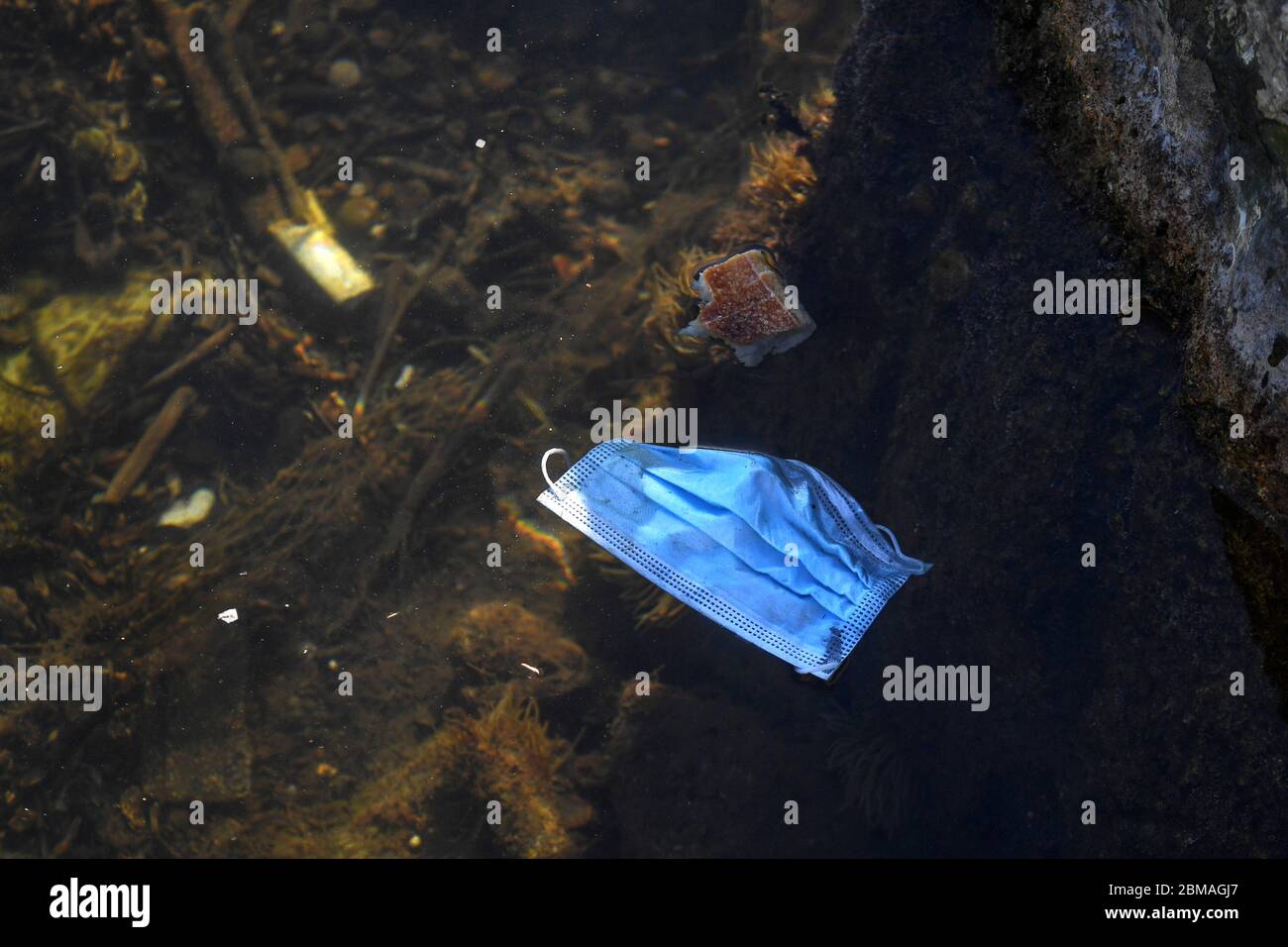 A protective mask for the mouth and nose thrown into the sea of the ...