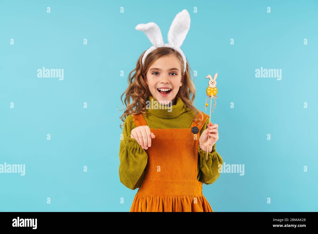 Photo of joyful blonde girl in fake rabbit ears acting like bunny and ...