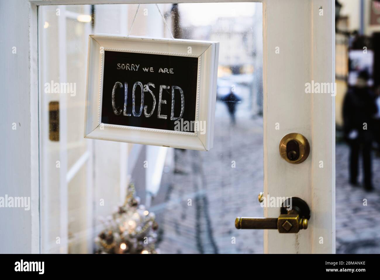 Sign CLOSED on restaurant or shop glass door. Street on background ...