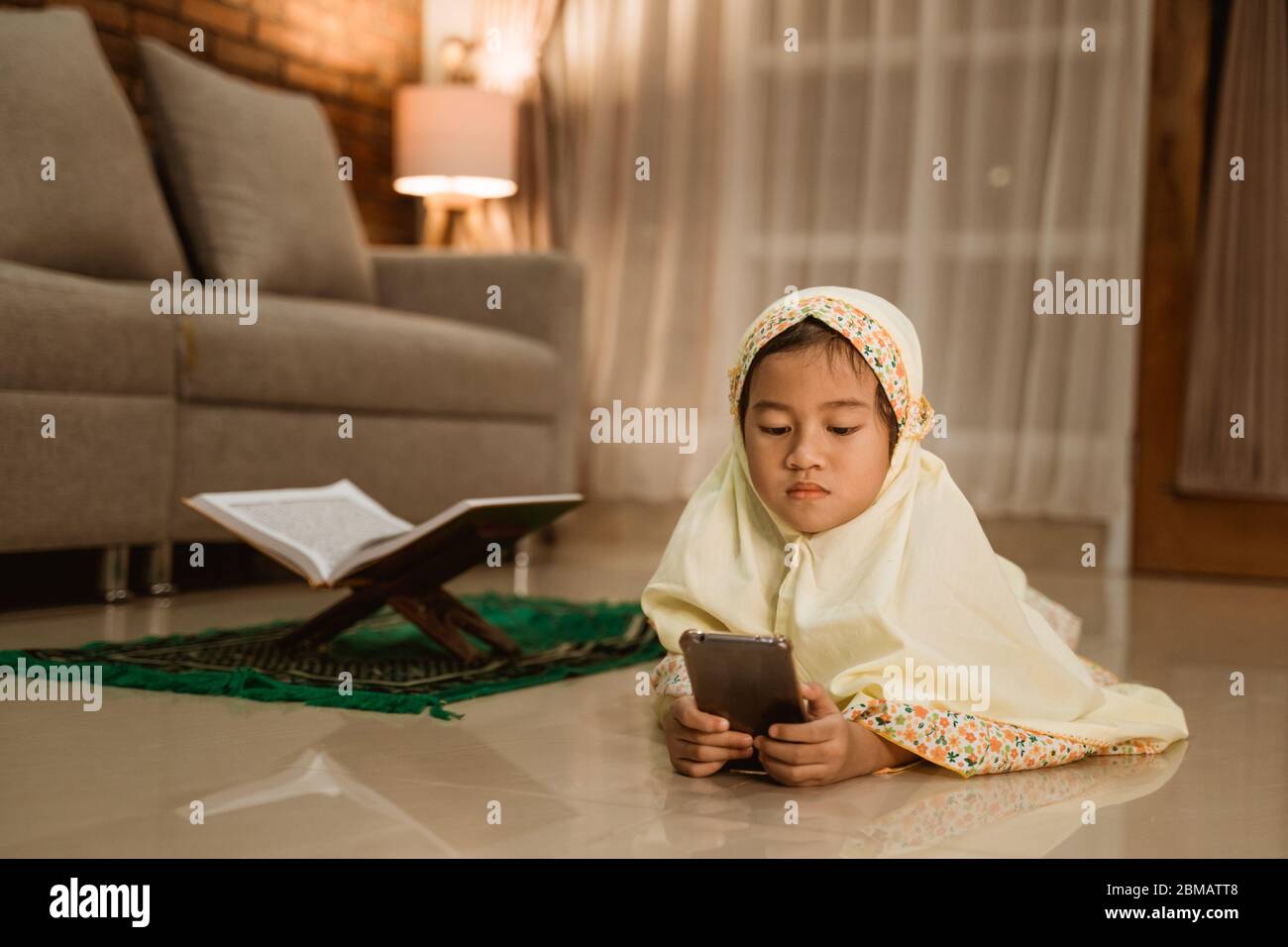 muslim kid using mobile phone after praying at home Stock Photo - Alamy