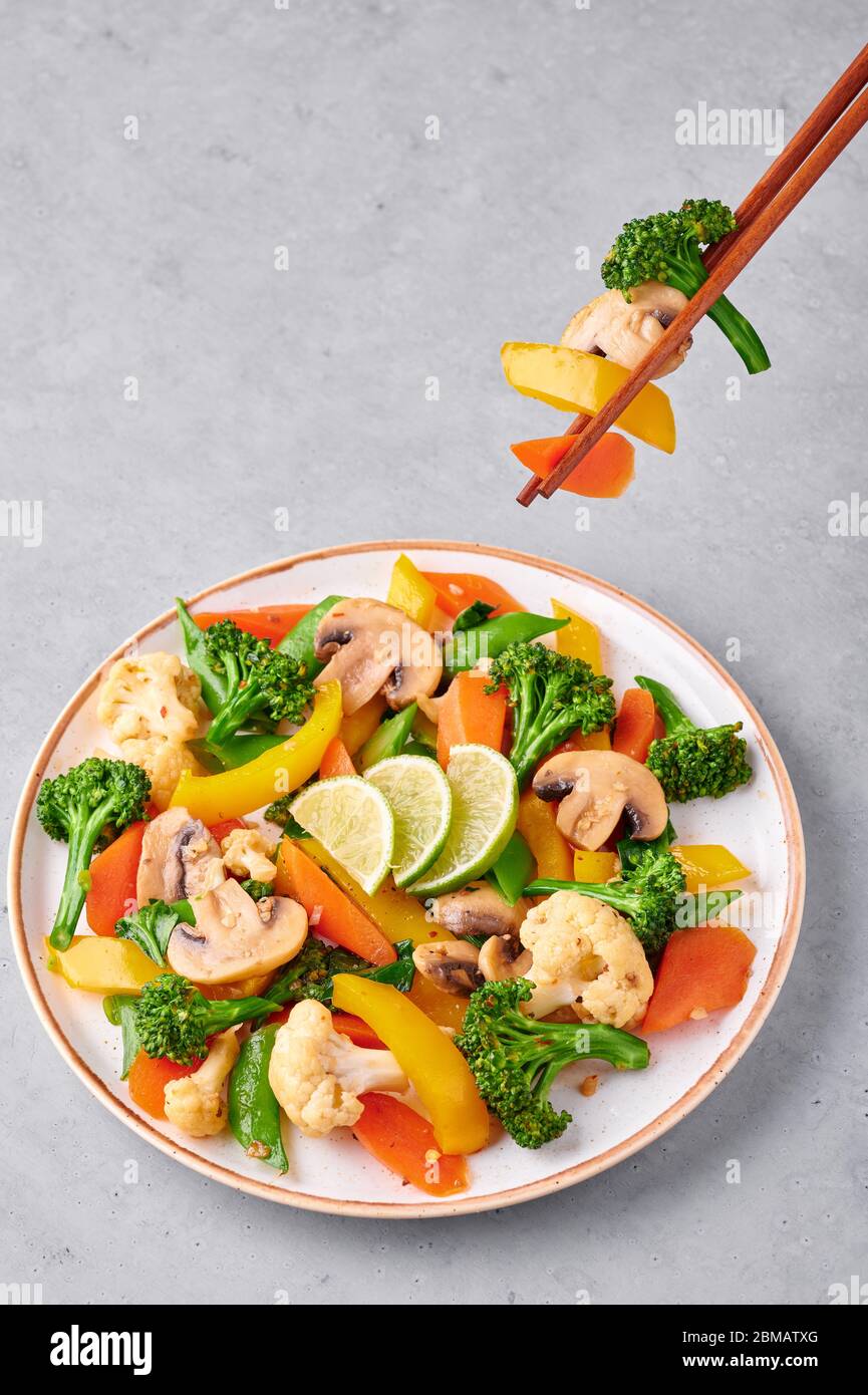 Pad Pak Ruam or Veg Thai Stir-Fried Vegetables in white plate on gray ...