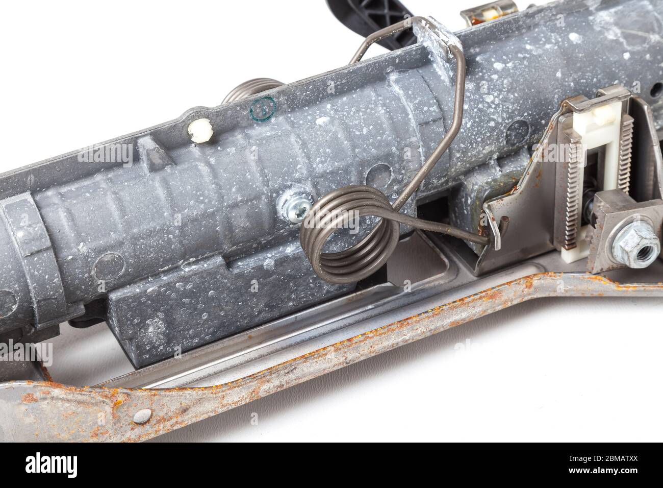 Metal spring in the mechanism of a used car close-up on a white ...