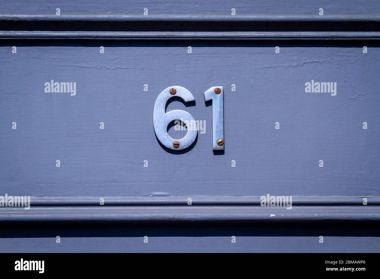 House number 61 on a wooden front door with strong horizontal lines in ...