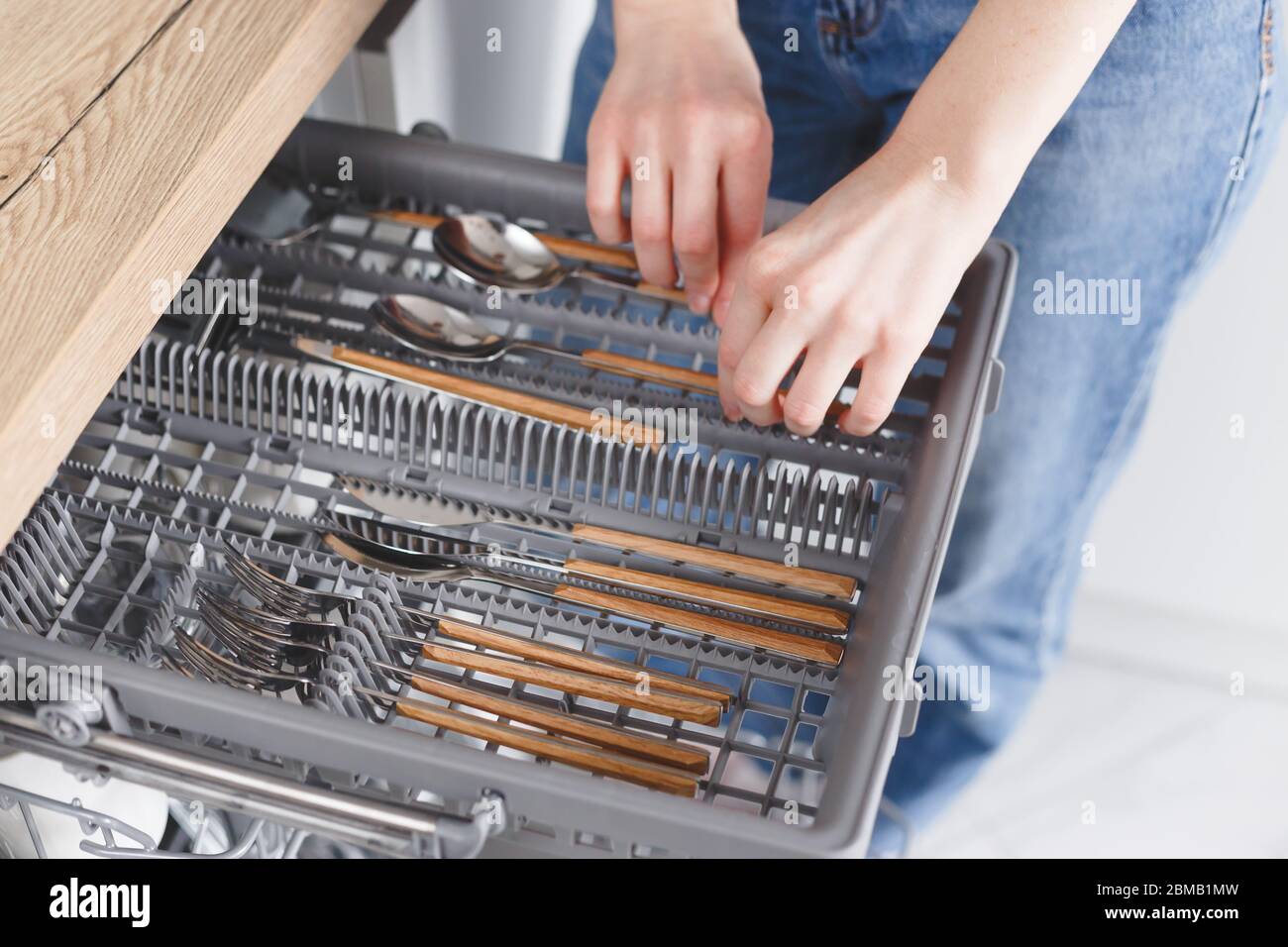 Woman washing cutlery in hi-res stock photography and images - Alamy