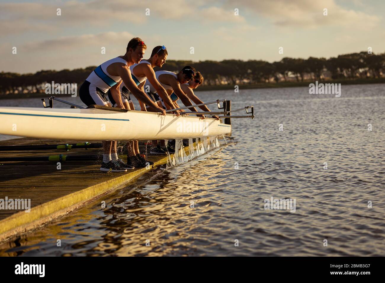 Caucasian men taking a boat out of water Stock Photo - Alamy
