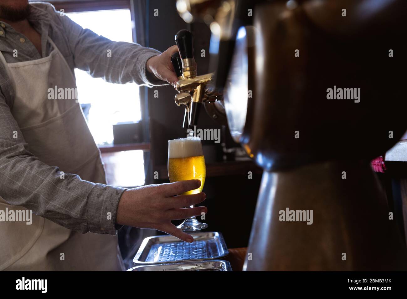 Caucasian barman serving a beer in a brewery Stock Photo - Alamy