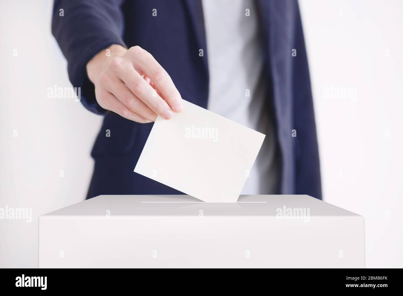 Man putting a ballot into a voting box Stock Photo - Alamy