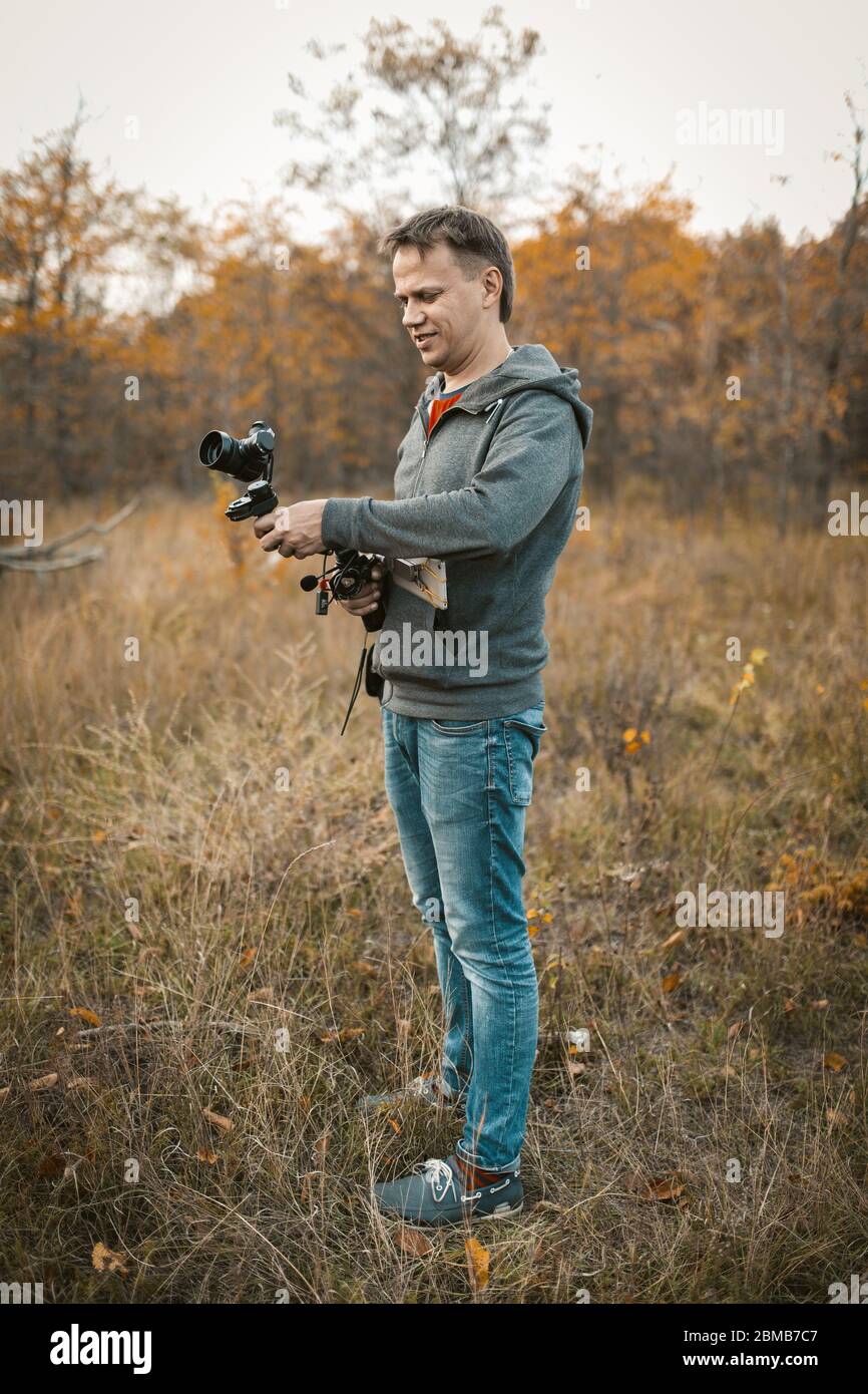 Positive camera man preparing camera on digital stabilizer for shooting ...