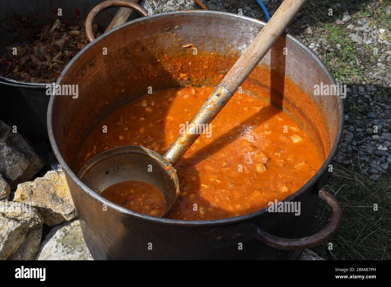 Very large cauldron cooking food during campfire, big pots on fire ...