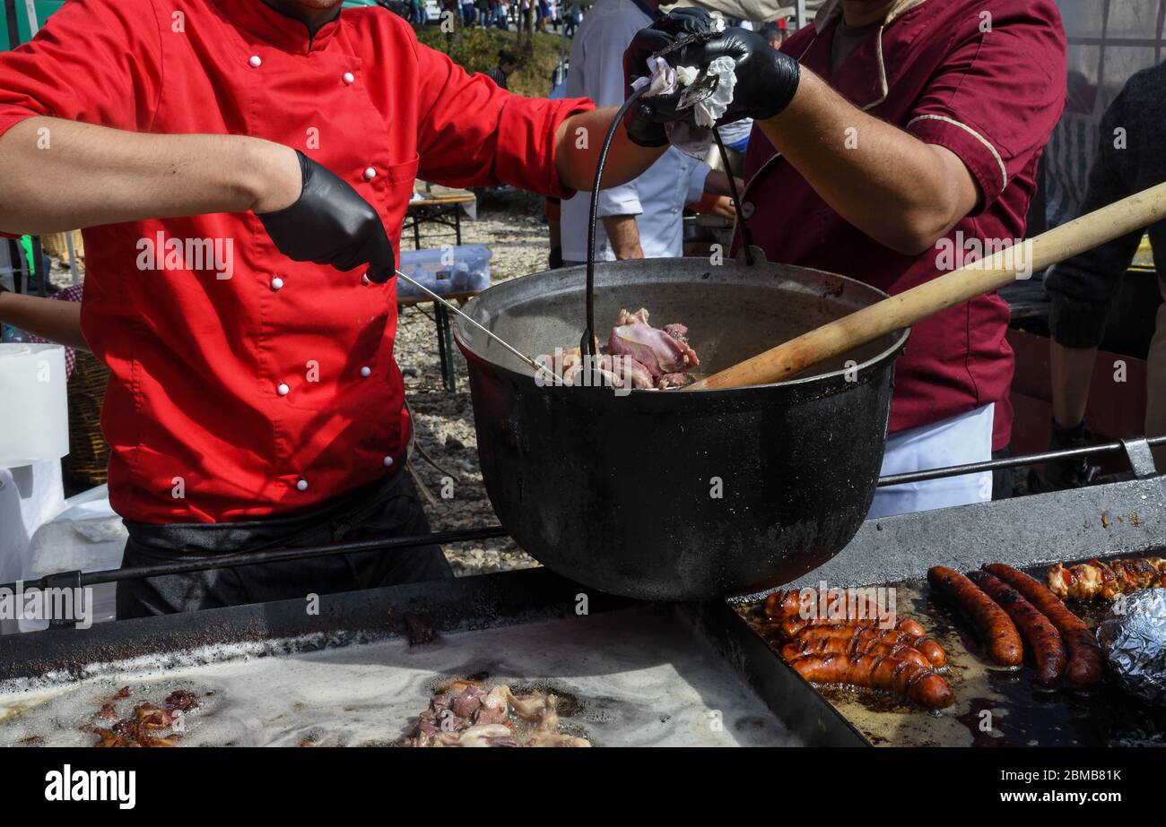 Very large cauldron cooking food during campfire, big pots on fire ...