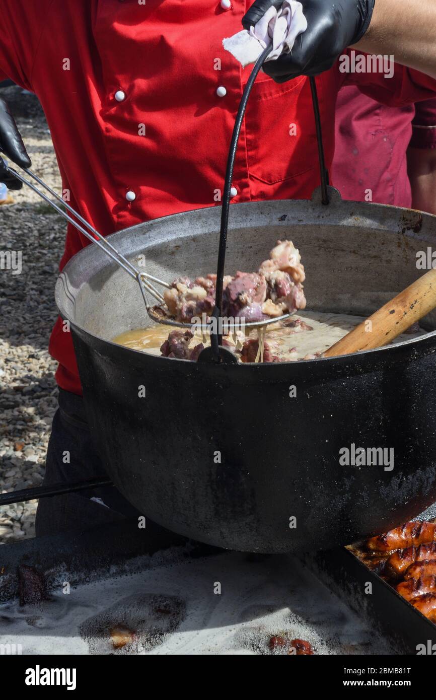 Very large cauldron cooking food during campfire, big pots on fire ...