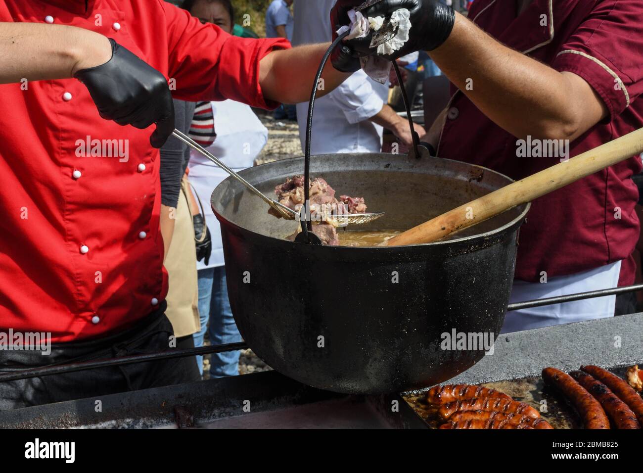 Very large cauldron cooking food during campfire, big pots on fire ...