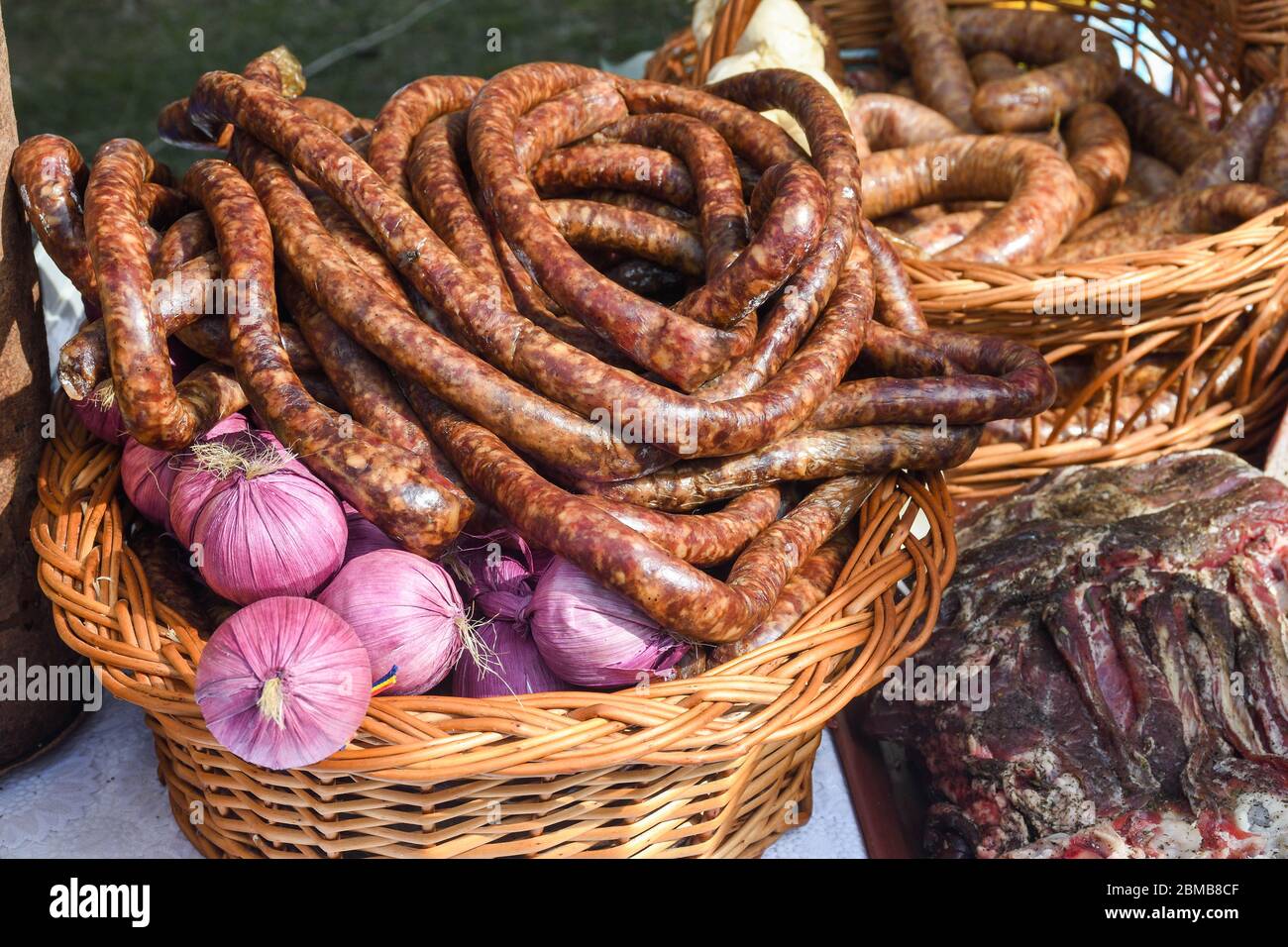 Assorted meat products, sausages, chorizo, spices on a dark table. View ...