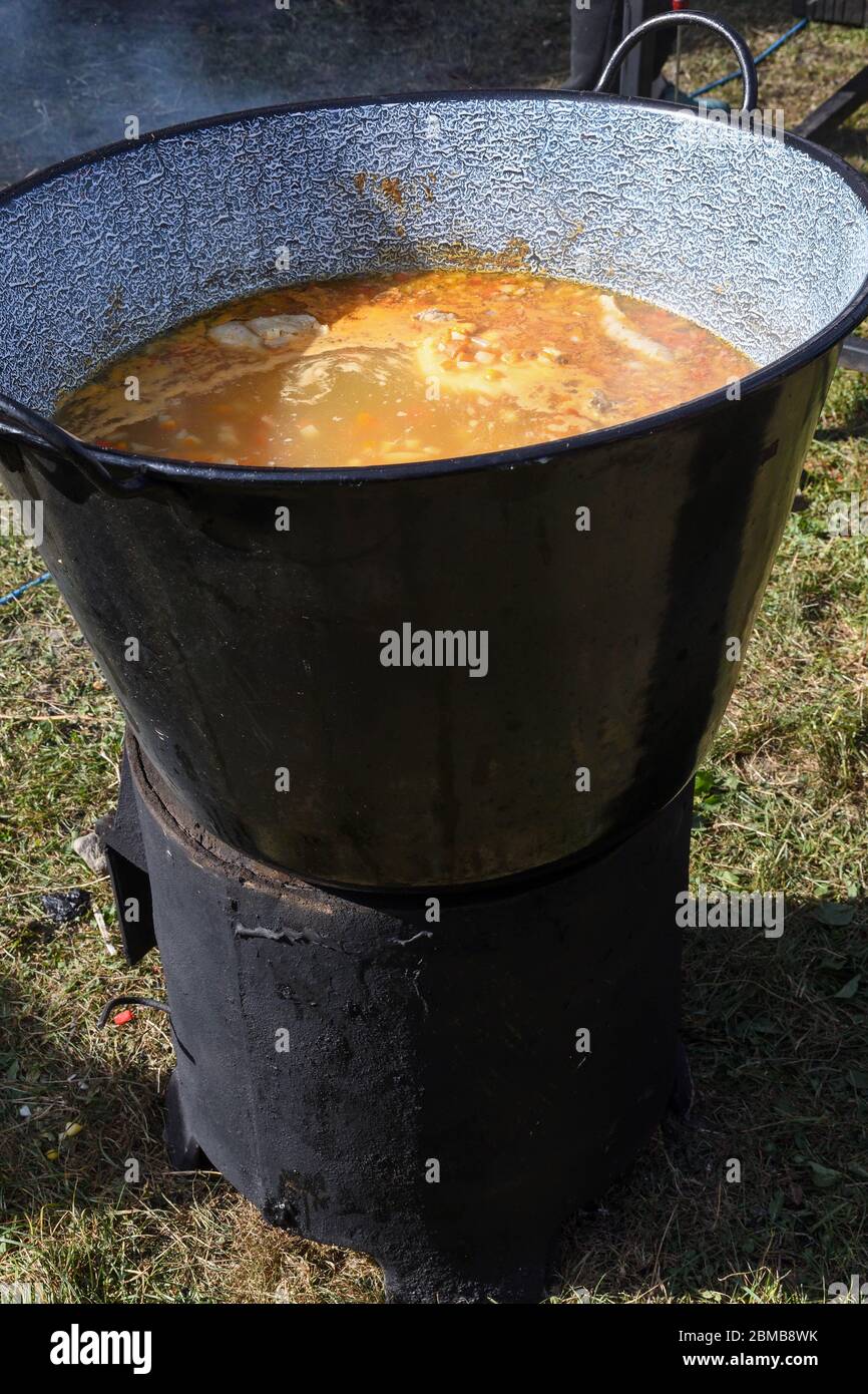 Very large cauldron cooking food during campfire, big pots on fire ...