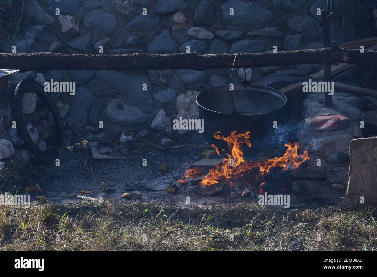 Very large cauldron cooking food during campfire, big pots on fire ...