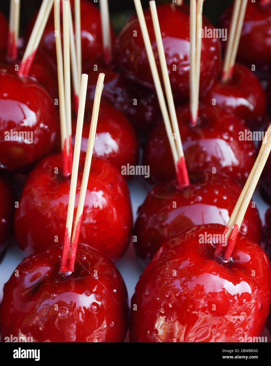 Sweet glazed red toffee candy apples on sticks for sale on farmer ...