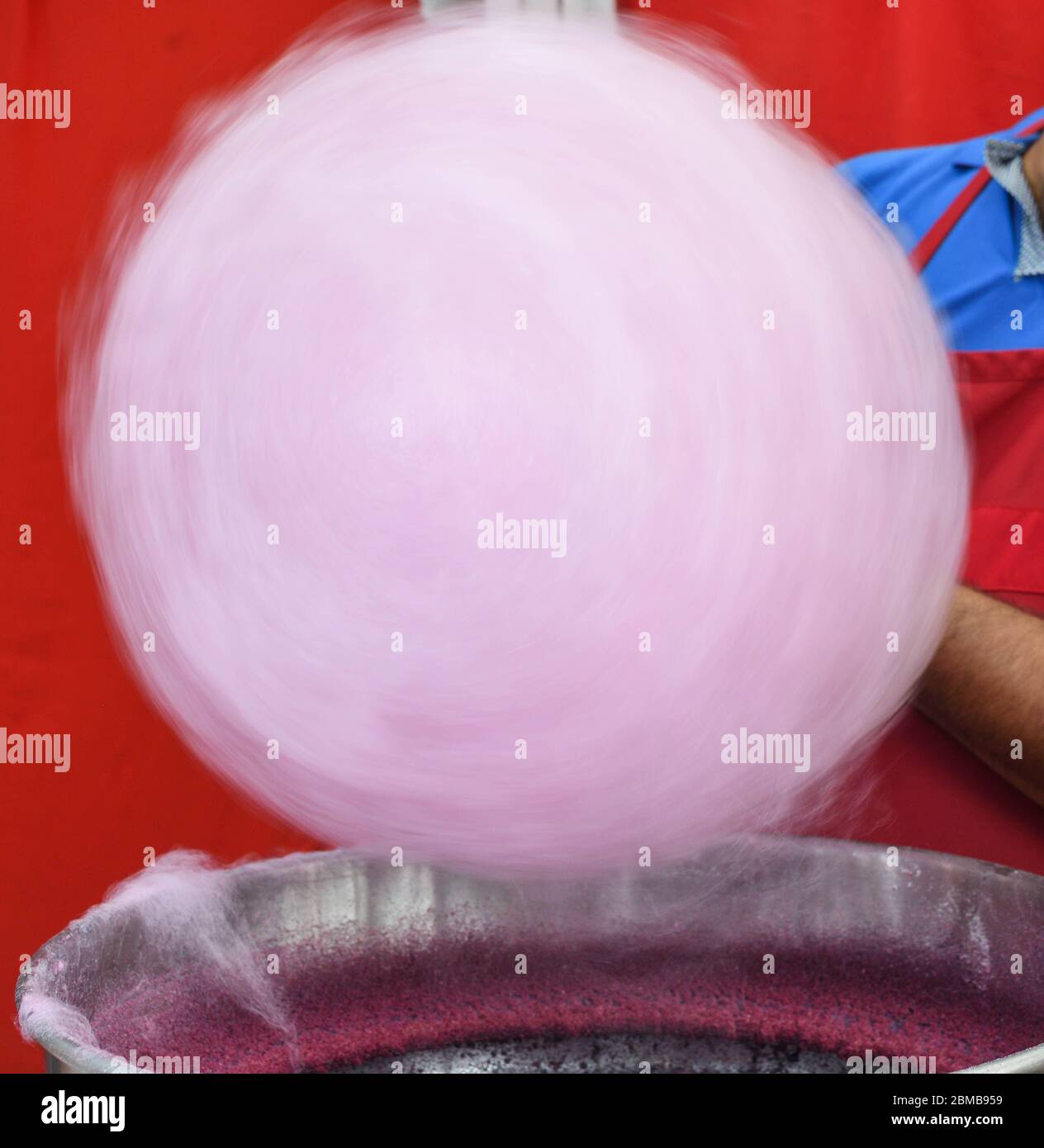 Hand rolling cotton candy in candy floss machine. Making candyfloss ...