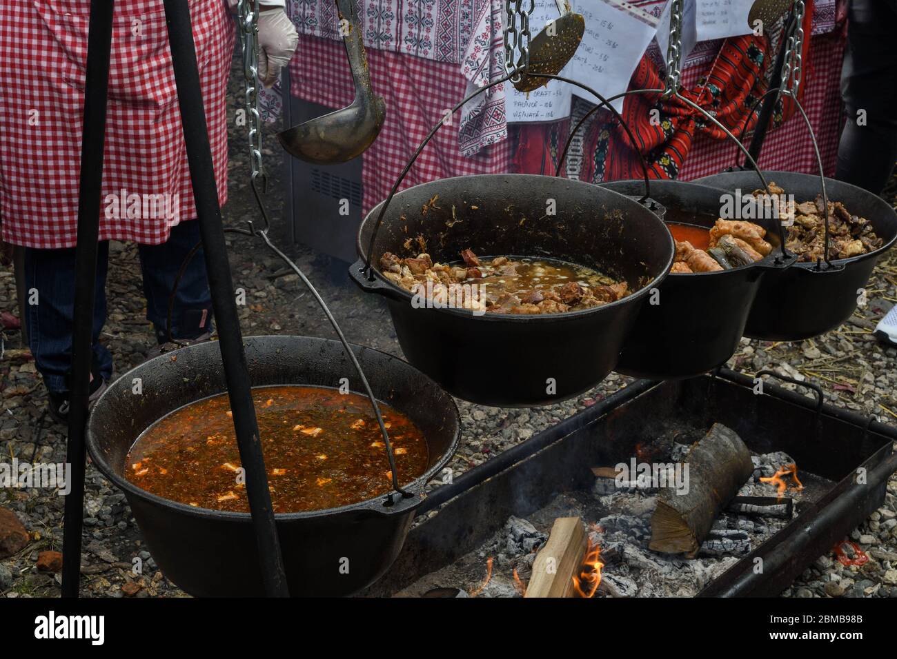Very large cauldron cooking food during campfire, big pots on fire ...