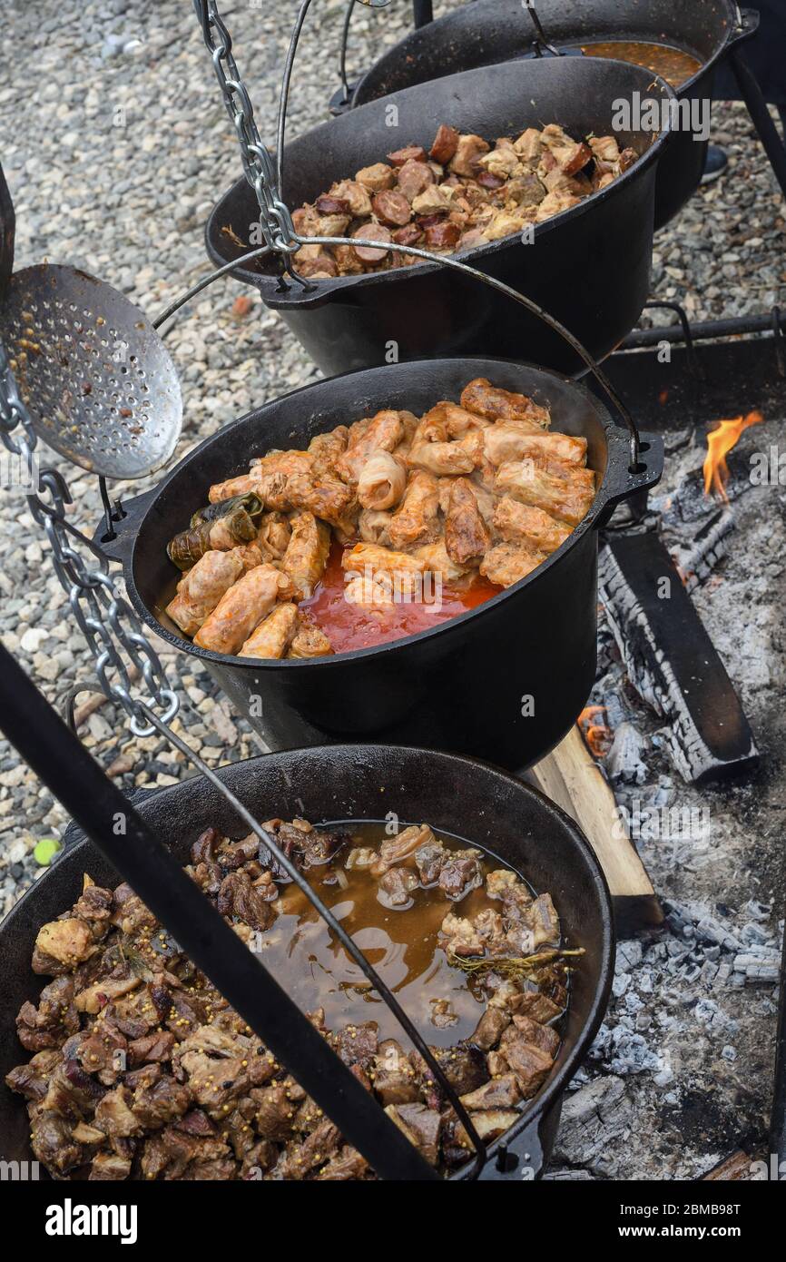 Very large cauldron cooking food during campfire, big pots on fire ...