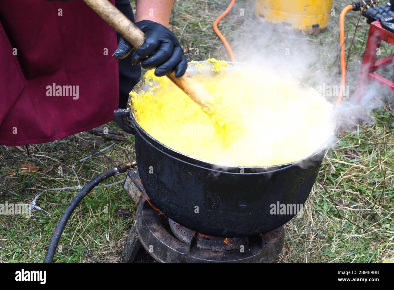 Very large cauldron cooking food during campfire, big pots on fire ...
