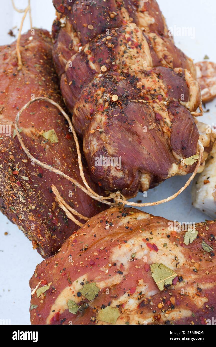 Assorted meat products, sausages, chorizo, spices on a dark table. View ...