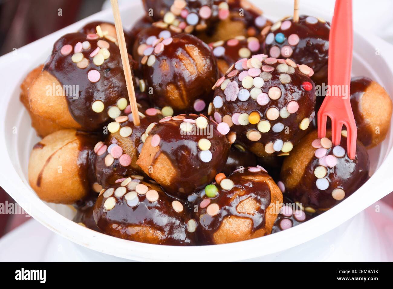 Fresh round small donuts during carnival or fast food festival, glazed ...