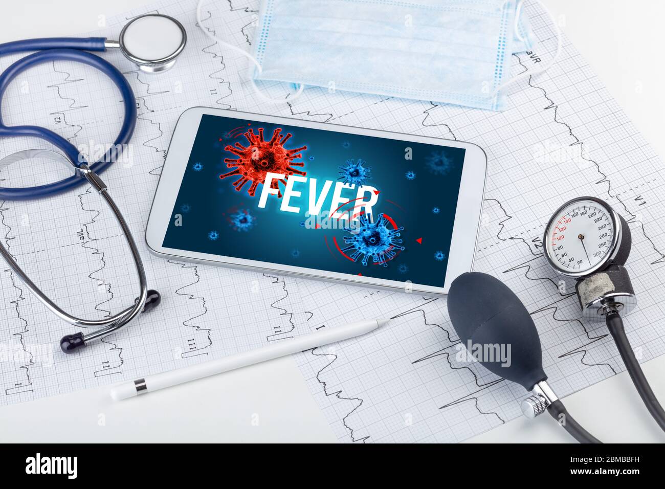 Tablet pc and doctor tools on white surface with FEVER inscription ...