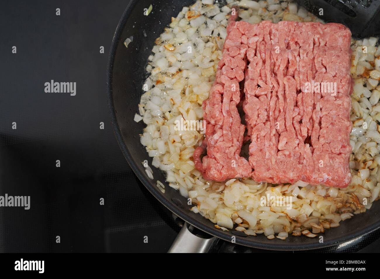 minced meat fried in onions in a black pan Stock Photo - Alamy