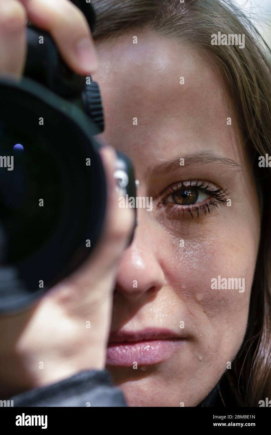a female reporter weeps while filming the tragedy. a look at the camera ...
