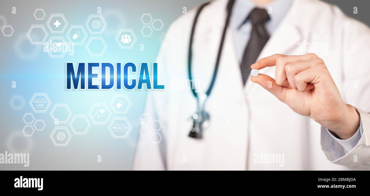Close-up of a doctor giving you a pill with MEDICAL inscription ...