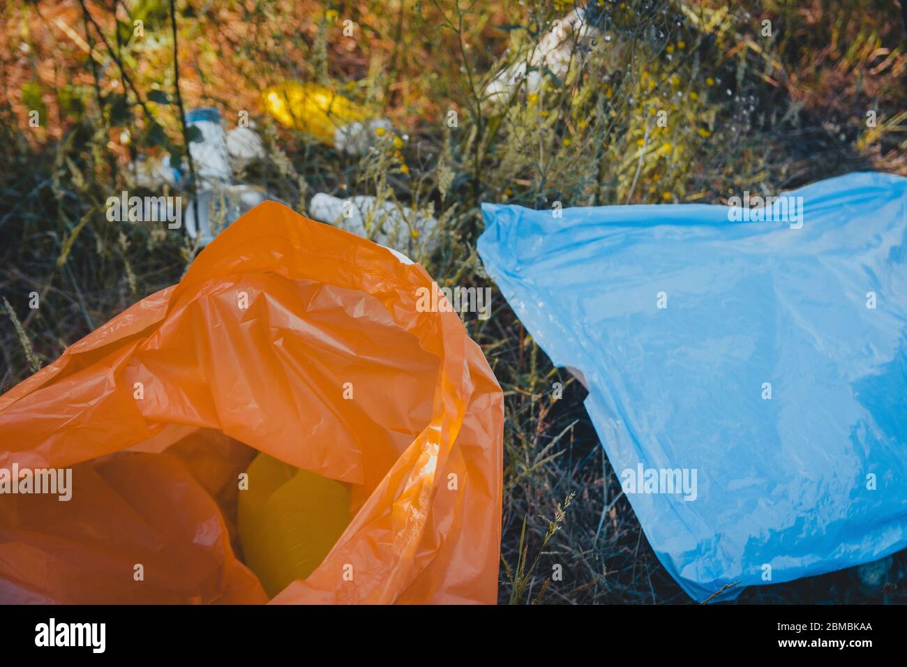 A high angle shot of a plastic garbage bag with recyclable bottles ...