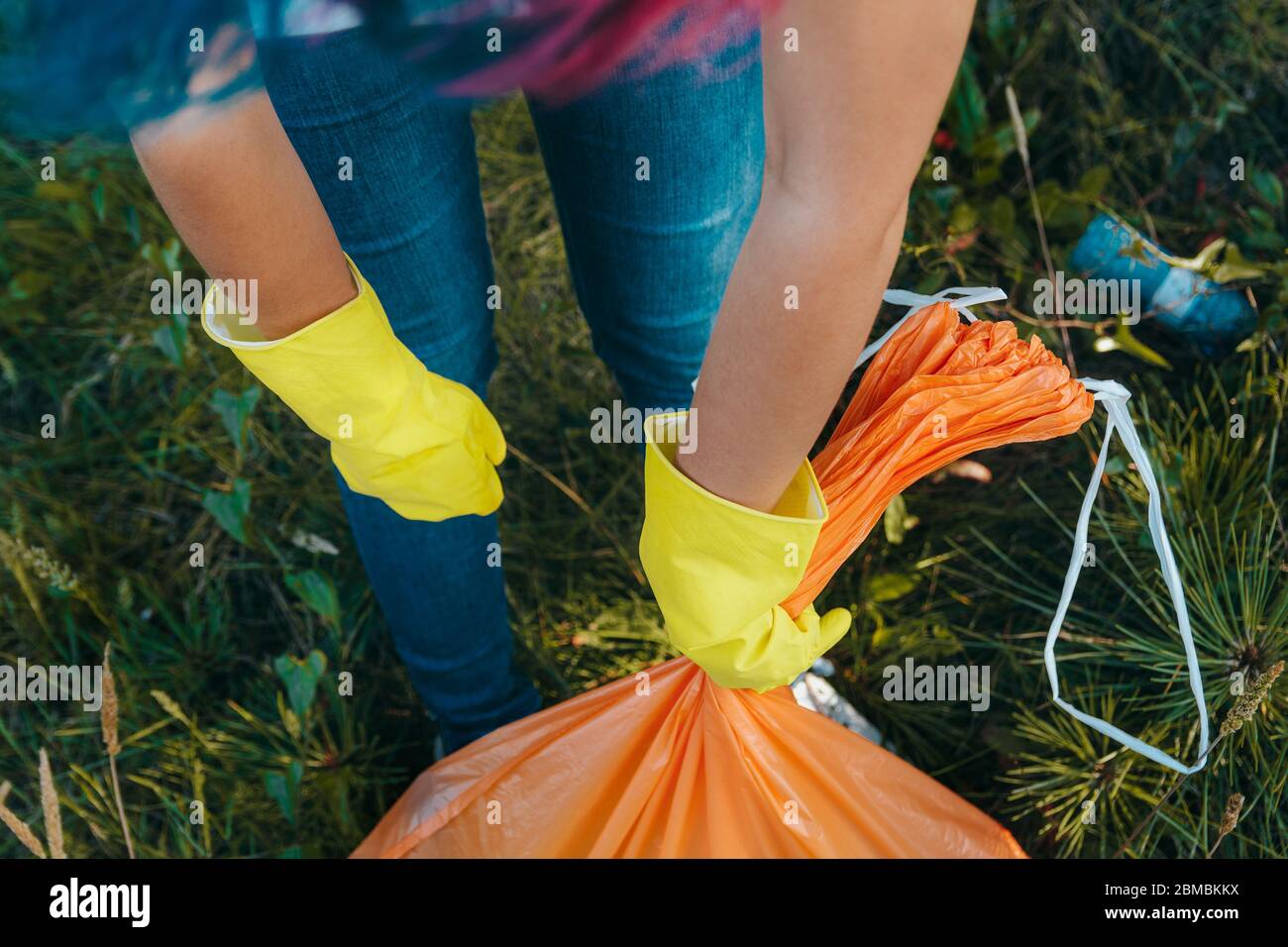 A young female collecting the trash and putting in a plastic garbage ...