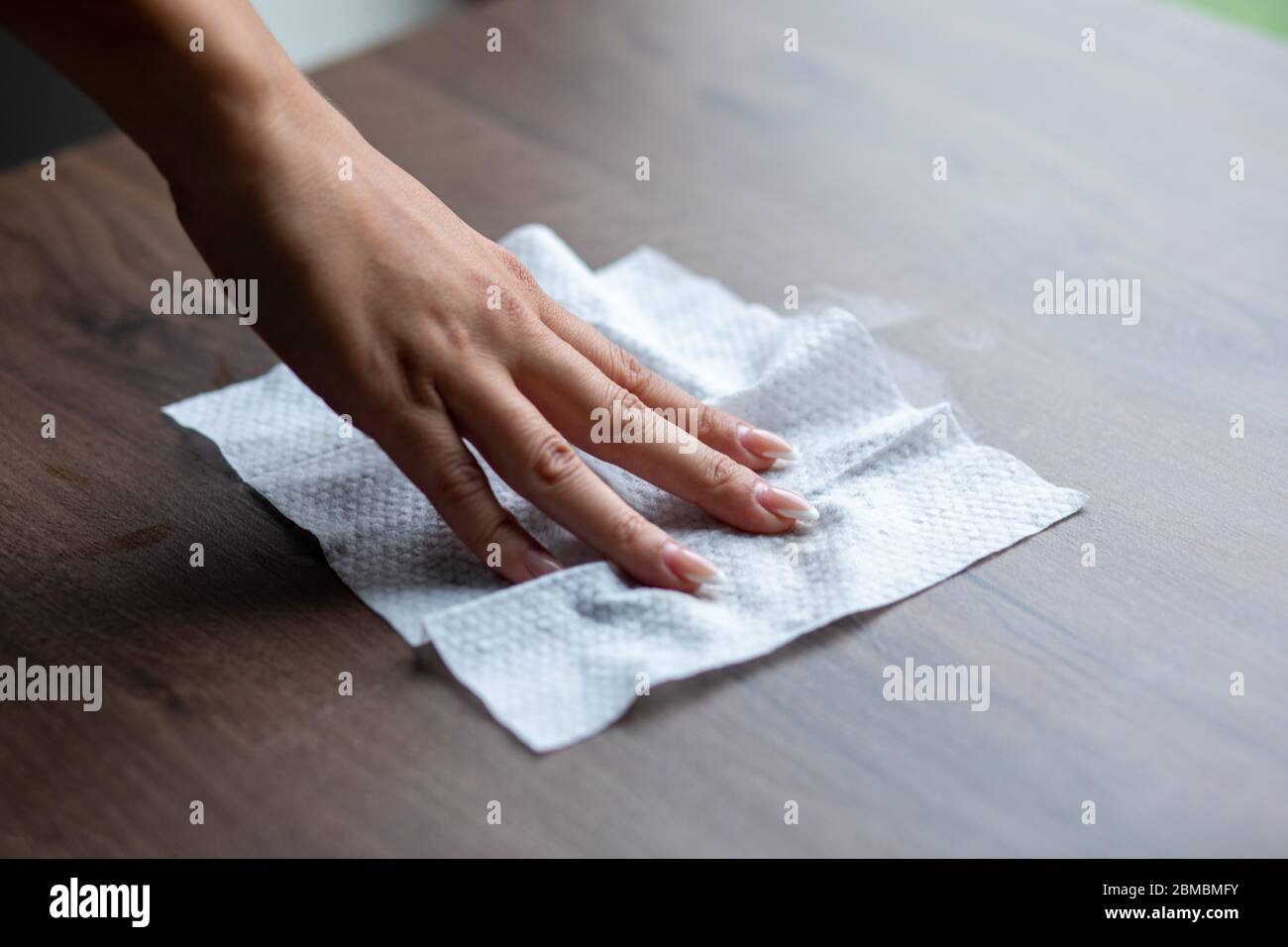 Woman's hand cleaning home office table surface with wet wipes Stock ...